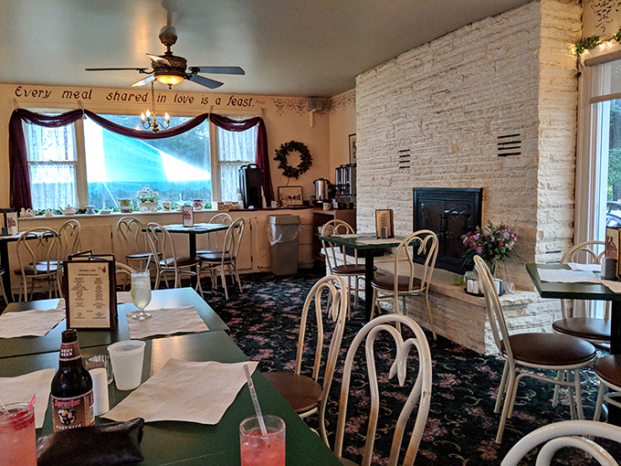"Every meal shared in love is a feast" isn't just wall decor—it's the philosophy that permeates this cozy dining room with its stone fireplace and vintage charm.