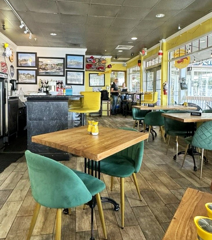 Cheerful yellow walls meet teal accents in this cozy interior where New England nostalgia mingles with Florida sunshine, creating the perfect chowder-slurping atmosphere.