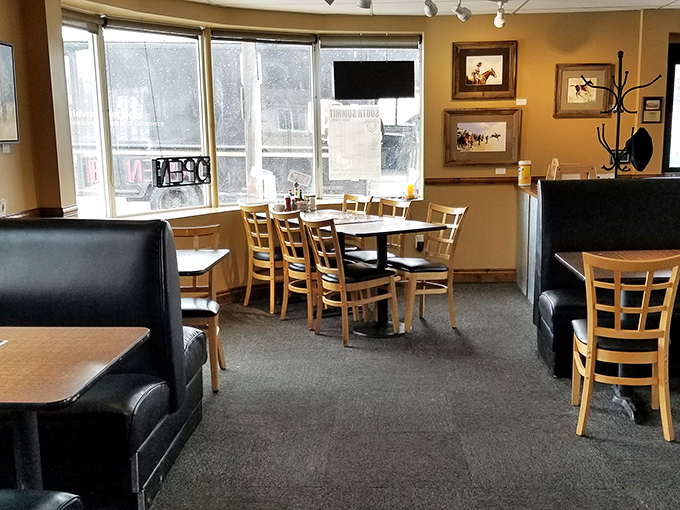 Sunshine streams through panoramic windows, illuminating a dining room where mountain charm meets classic diner comfort.