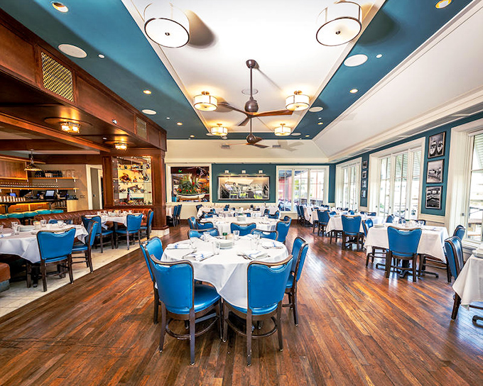 Nautical elegance meets Florida charm in this dining room where polished wood, crisp white linens, and those signature blue chairs set the stage for seafood magic.