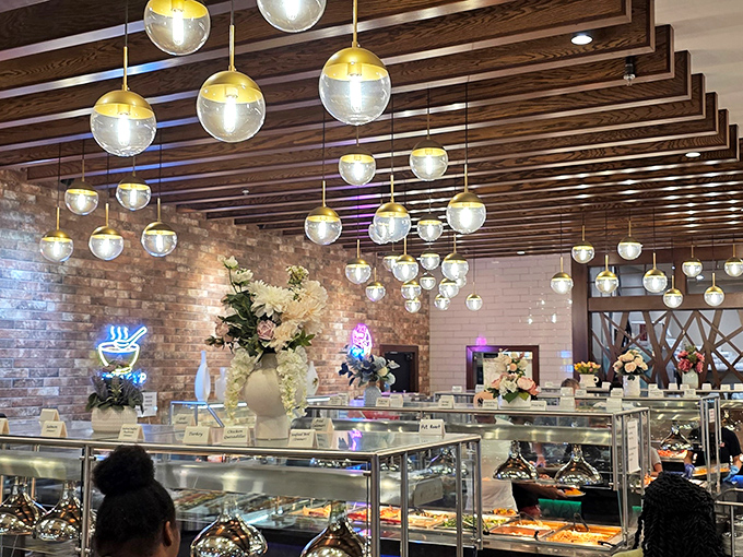 Suspended globe lights create a constellation of warmth above the buffet stations, where gleaming glass and fresh flowers promise a dining experience that's anything but ordinary.