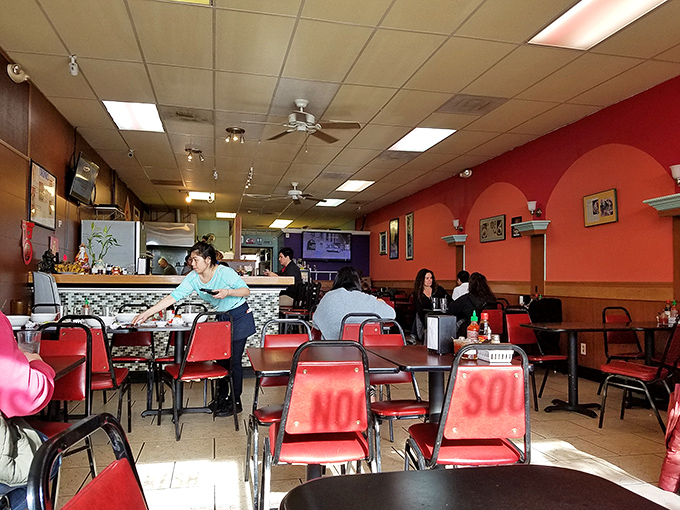 Inside, vibrant orange walls and red chairs create a no-frills atmosphere where the food, not the decor, rightfully takes center stage.