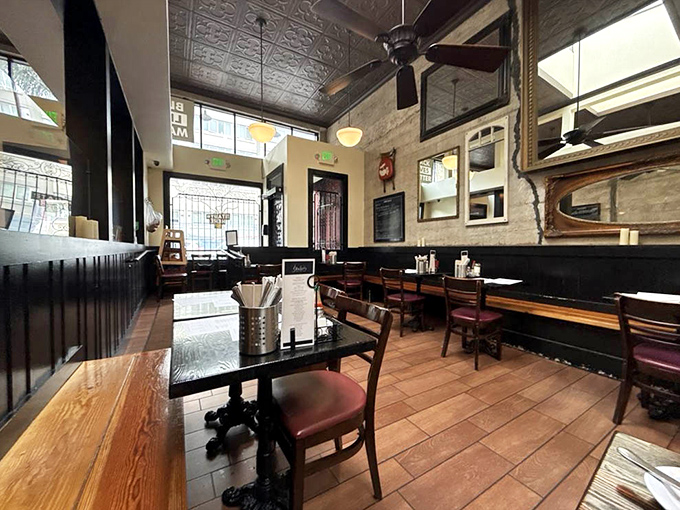 Pressed tin ceilings, wooden tables, and warm lighting create that rare atmosphere where comfort meets cool without trying too hard.