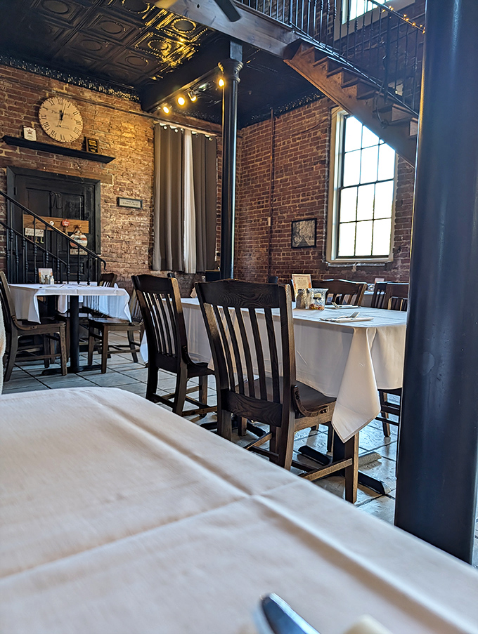 Exposed brick walls, pressed tin ceilings, and white tablecloths create that perfect balance of rustic charm and refined dining that makes you instantly feel at home.