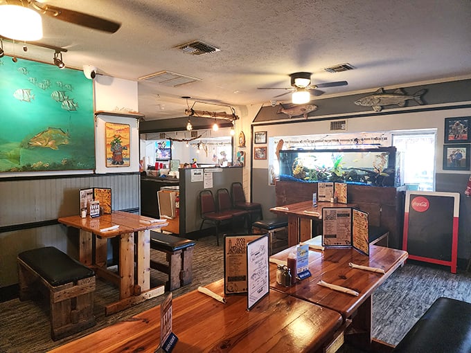 Wooden tables, fishing art, and aquarium views create the perfect backdrop for your upcoming seafood feast.