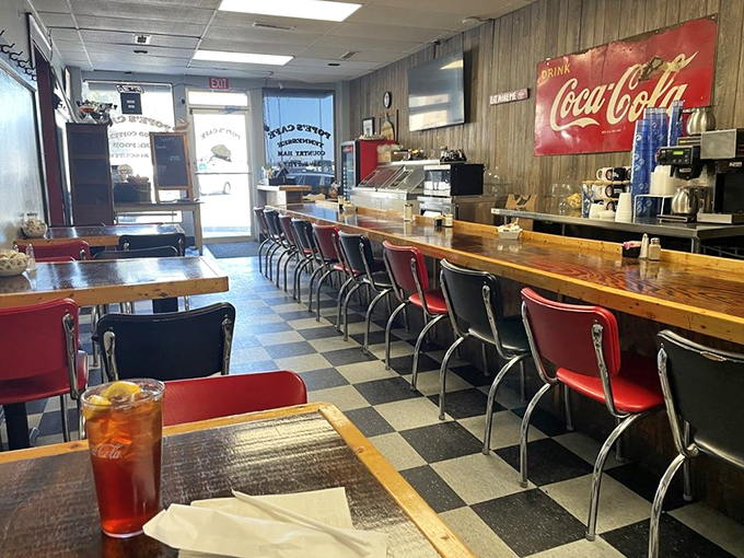 Step inside to a world where red vinyl meets wood paneling, and the checkered floor tells stories of countless Tennessee mornings spent in good company.