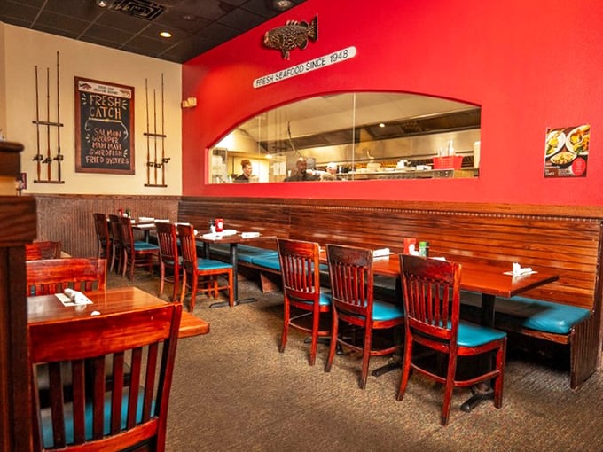 Warm wooden booths with turquoise cushions create that perfect "not-too-fancy, not-too-casual" vibe where serious seafood enjoyment happens.