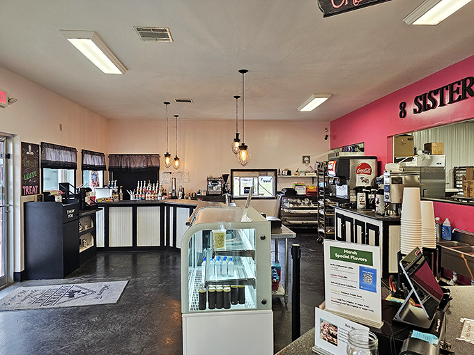 Edison bulbs cast a warm glow over black and white counters, while that pink accent wall says, "Yes, happiness lives here, and it's calorie-dense."