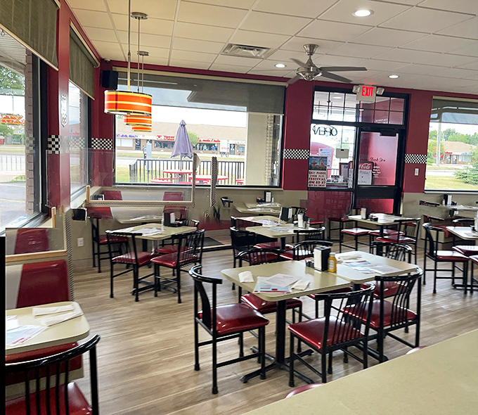 Classic red vinyl chairs and checkered accents create that perfect diner atmosphere where conversations flow as freely as the coffee refills.
