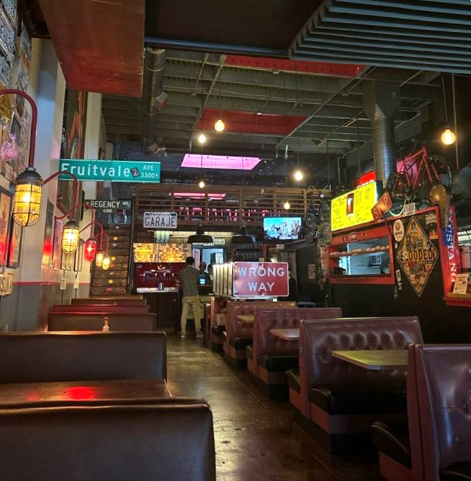 Inside Garaje, street signs and moody lighting create the perfect urban sanctuary. The "WRONG WAY" sign isn't deterring anyone from the right food choices.