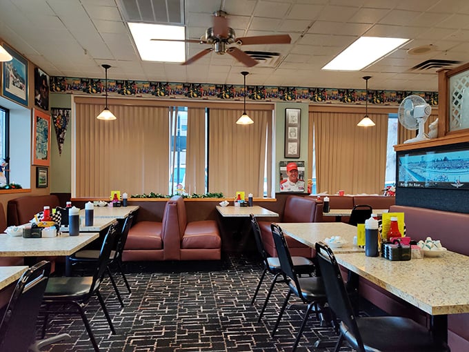 Cozy maroon booths and pendant lighting create that classic diner atmosphere where breakfast dreams come true and coffee cups never stay empty.
