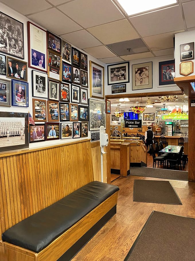 The wall of fame greets you like a celebrity yearbook of satisfied customers, while the legendary pickle bar beckons in the background.