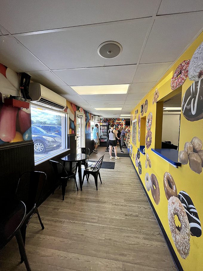 Yellow walls adorned with donut portraits create an art gallery where every masterpiece is edible. The Louvre of fried dough awaits.