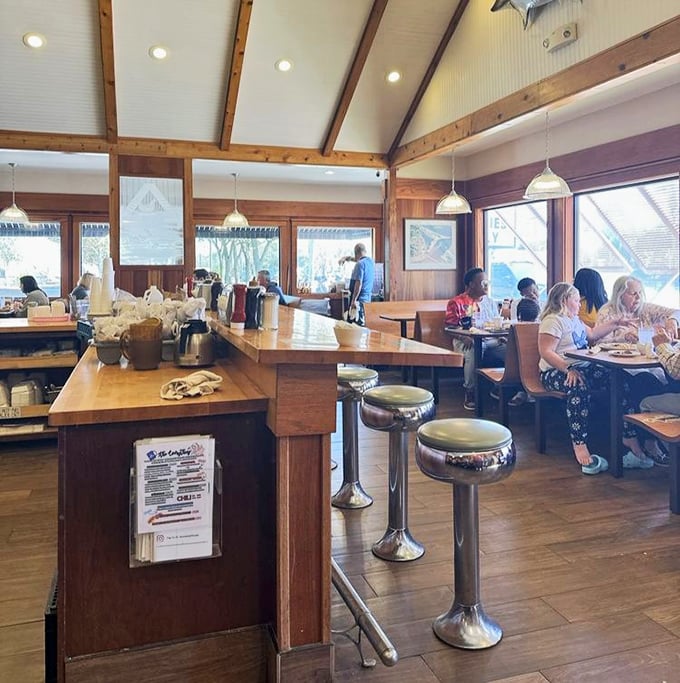 Warm wood paneling, vaulted ceilings, and chrome counter stools create that perfect blend of beach house comfort and classic diner nostalgia.