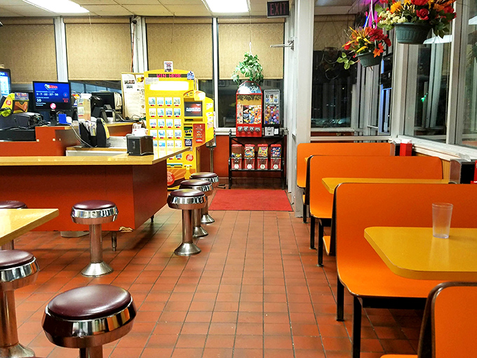 Orange booths and chrome stools create a retro vibe that says "we're serious about breakfast, not about impressing design magazines."