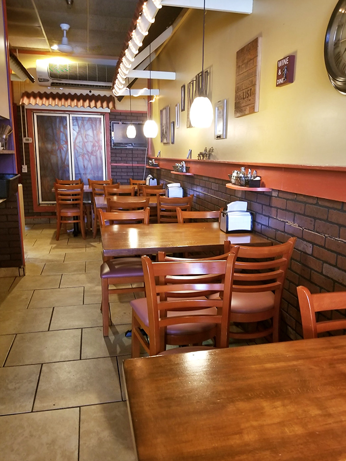 The cozy interior features warm yellow walls, brick accents, and wooden tables that invite you to settle in for a meal that feels like coming home.