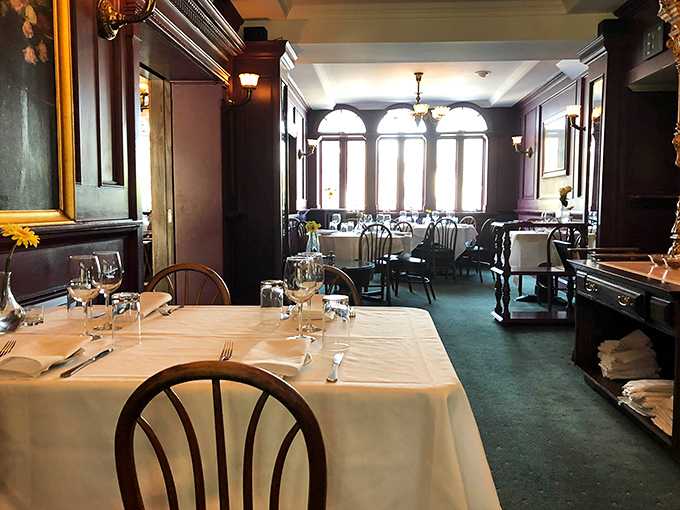 Dark wood paneling and crisp white tablecloths create an atmosphere that whispers, "Put your phone away and savor this moment."