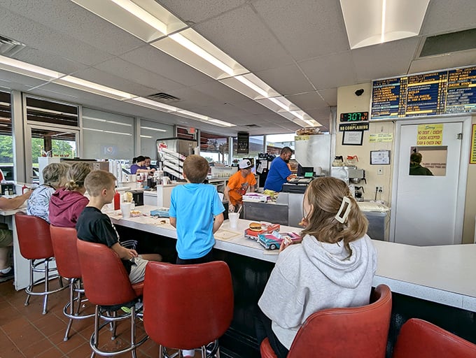 Classic red counter stools where strangers become friends over massive burgers and shared amazement.