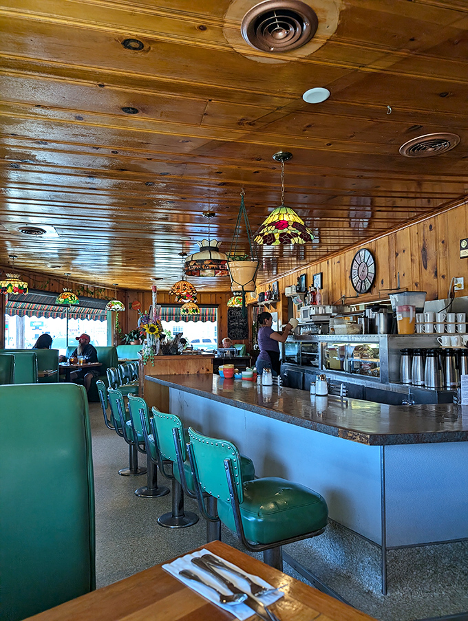 Warm wood paneling and colorful Tiffany-style lamps create the perfect backdrop for breakfast magic, while turquoise booths invite you to settle in.
