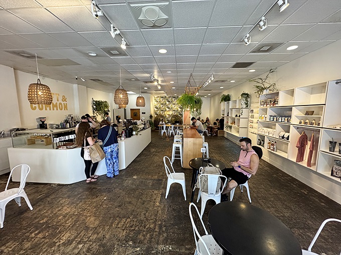 Inside, minimalist design meets cozy comfort. The hanging wicker lamps and abundant greenery create an oasis where coffee and conversation flow freely.