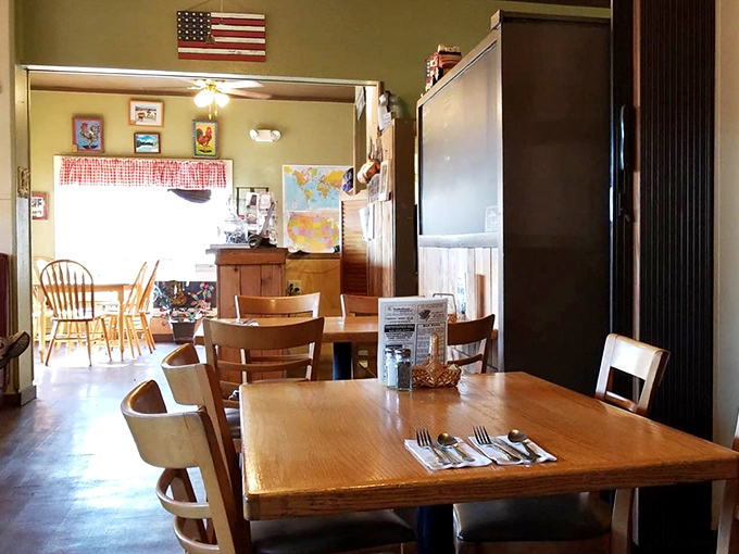Simple wooden tables and chairs beneath an American flag create that rare atmosphere where conversations flow as easily as the coffee.