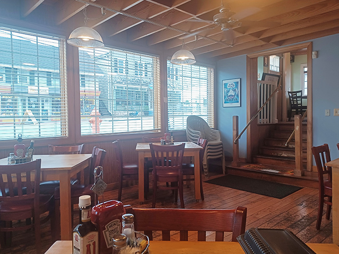 Sunlight streams through large windows, illuminating wooden tables where countless crab feasts have unfolded. The blue walls echo the Chesapeake's waters.