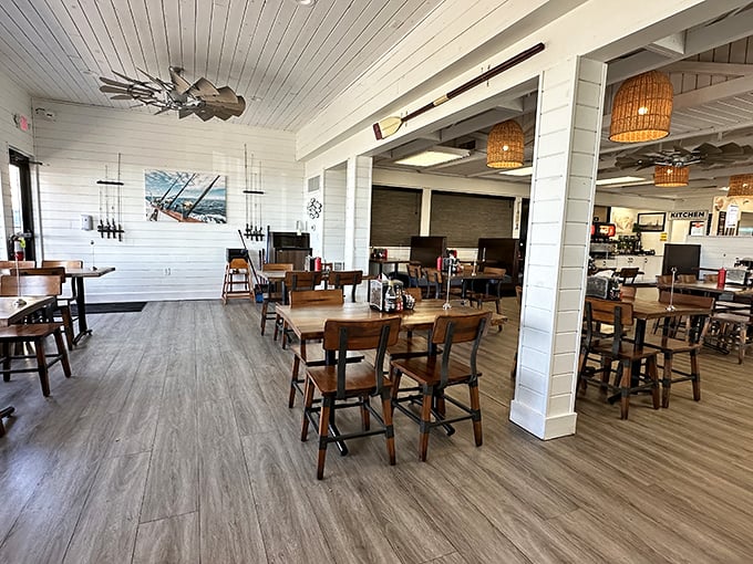 Nautical charm meets modern comfort in this bright, airy dining room where wicker pendant lights cast a warm glow over wooden tables.