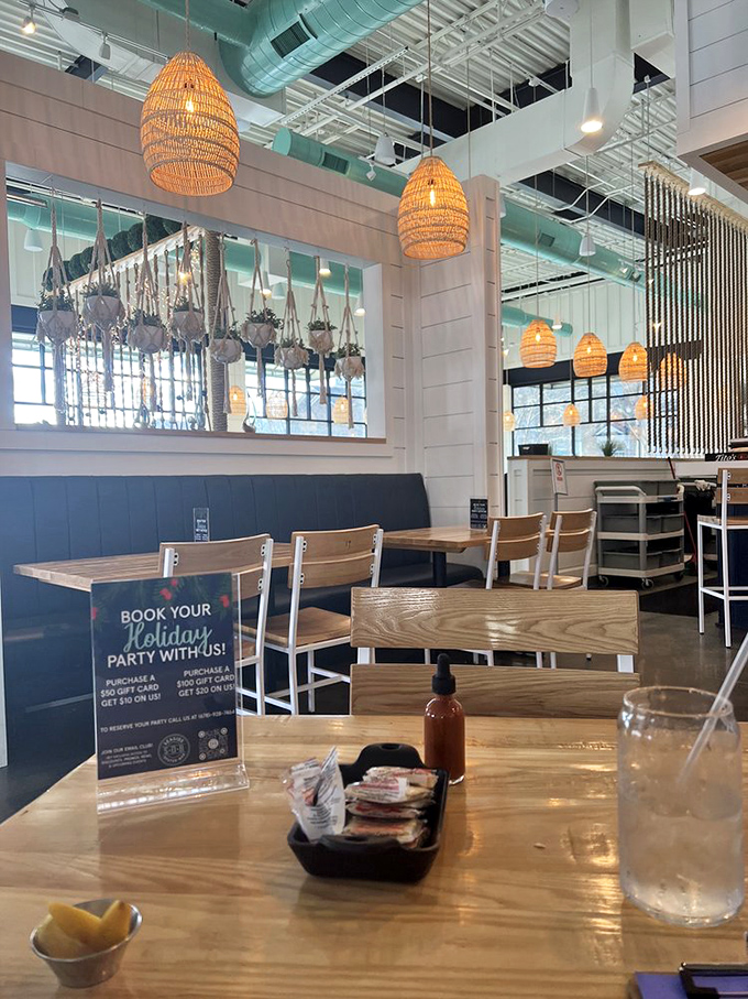 Woven basket pendant lights hang like stylish fishing traps, casting a warm glow over the coastal-chic interior.