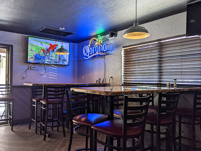 Blue neon casts a cool glow over the bar area, where cold Corona and sports on TV create the perfect Florida happy hour vibe.