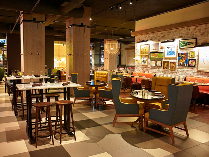 Where rustic meets refined &ndash; colorful chairs pop against checkerboard floors while exposed brick walls showcase local art. Comfort disguised as elegance.