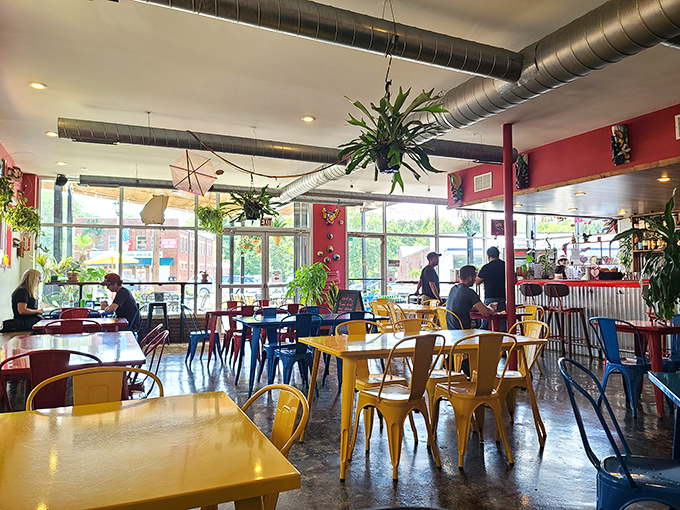 Inside, the industrial-meets-tropical vibe creates the perfect backdrop for your Venezuelan feast. Those colorful chairs aren't just stylish&mdash;they're happiness in furniture form.