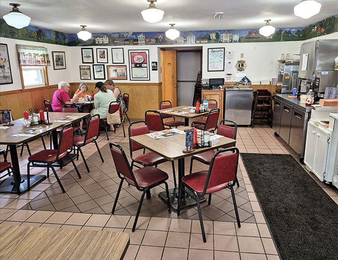 Classic red chairs and wooden wainscoting create that perfect diner atmosphere where conversations flow as freely as the coffee.