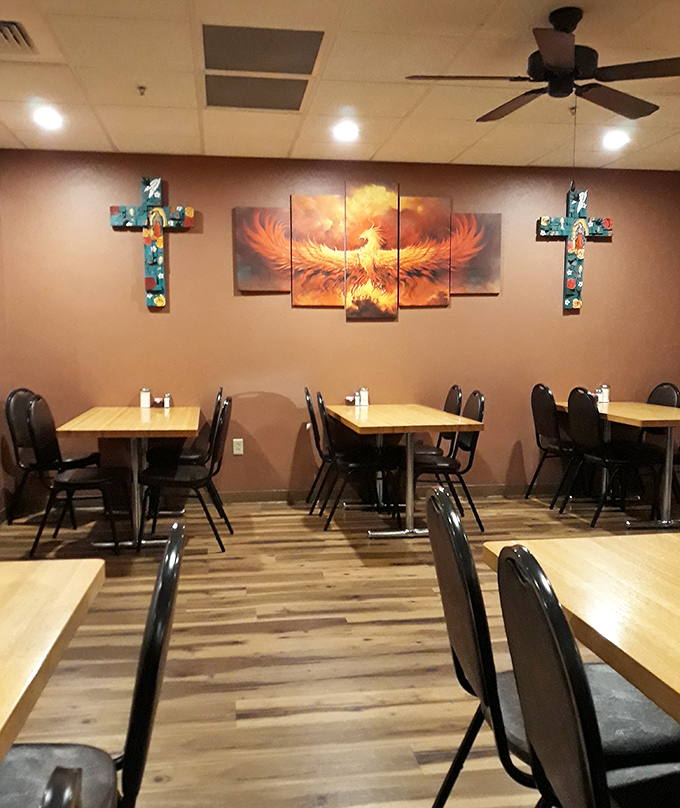 The phoenix mural watches over diners like a spicy guardian angel, while colorful crosses remind you that in Mexican cuisine, food is practically a religious experience.