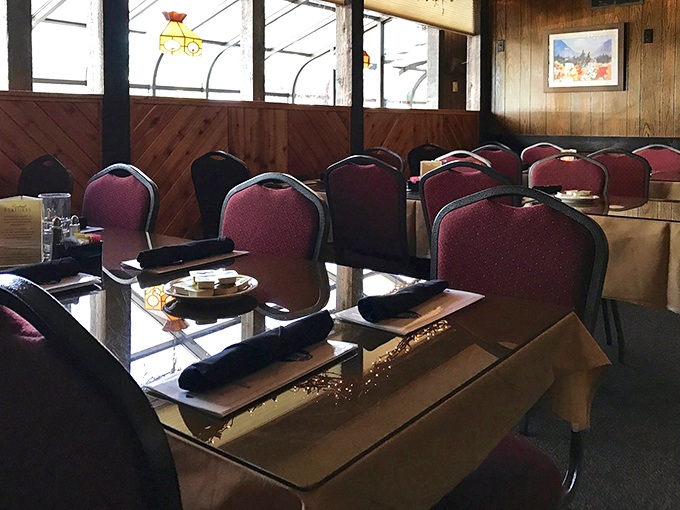 The dining room whispers "mountain charm" with its burgundy chairs and wood-paneled walls. Comfort first, pretension never.