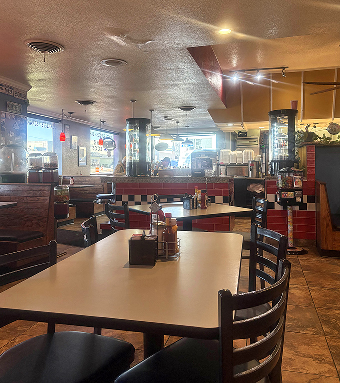 Classic diner geometry: red tile counter, checkered accents, and booths designed for comfort, not Instagram. This is where breakfast dreams come true.