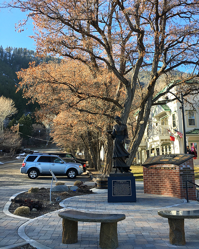 History stands tall in bronze, commemorating local heritage against a backdrop of autumn-painted trees and historic architecture.