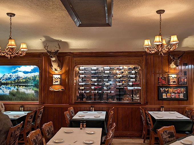 Antler chandeliers cast a golden glow across wood-paneled walls, while mounted deer stand sentinel over diners enjoying their carnivorous feasts.