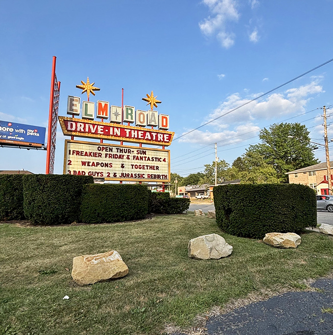 That iconic neon sign announces tonight's cinematic adventures. Nothing says "summer night" quite like those yellow stars and bold red letters.