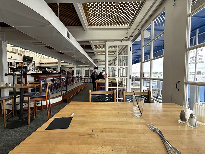 Wooden tables bathed in natural light offer front-row seats to the harbor ballet of bobbing boats and gliding seagulls.
