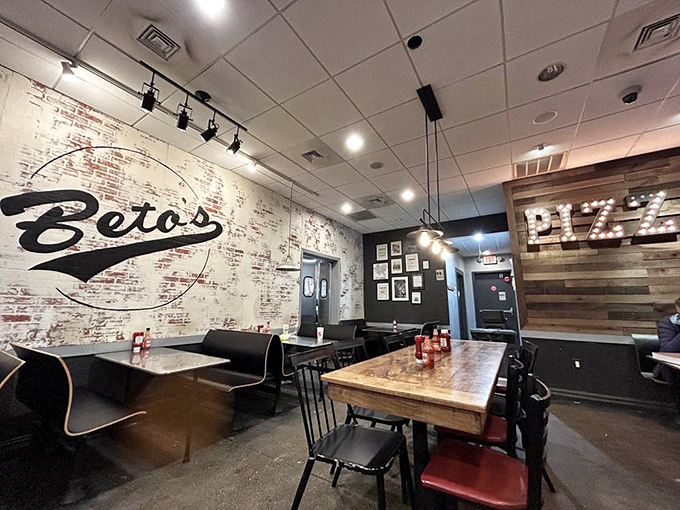 Inside, exposed brick walls and wooden tables create the perfect stage for pizza drama to unfold. The "PIZZA" sign glows like Broadway lights for cheese enthusiasts.