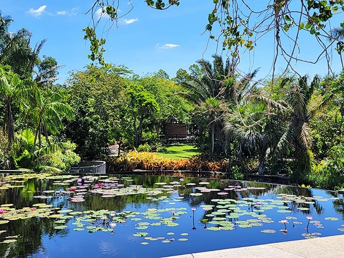 Nature's mirror at its finest. The lily pad-dotted waters reflect the surrounding tropical paradise, creating a double dose of beauty for garden visitors.