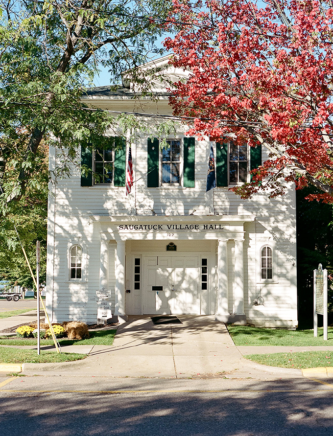 Saugatuck Village Hall stands proud in its white-painted glory, proving government buildings can actually be photogenic.