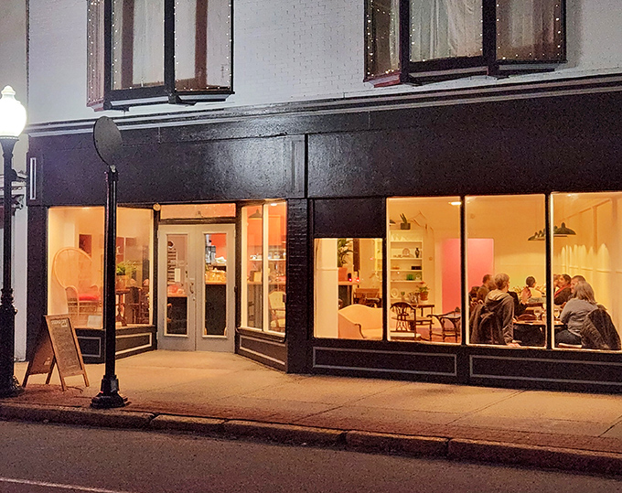 Evening glow transforms this downtown eatery into a beacon of community, where conversations flow as freely as the locally-sourced menu offerings.
