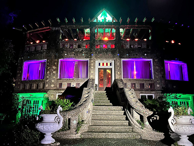 After sunset, Wonder House transforms into a technicolor dream, its purple-lit windows and green-glowing staircases creating an otherworldly nighttime spectacle.