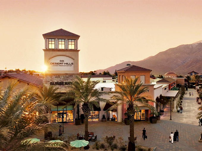 Sunset transforms Desert Hills into a shopper's paradise, with Burberry's iconic storefront glowing against mountain silhouettes like a fashion beacon in the desert.