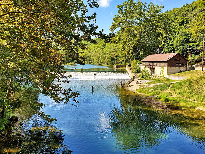 Anglers line the pristine waters while a rustic building stands sentinel nearby – this isn't just fishing, it's therapy with the possibility of dinner.