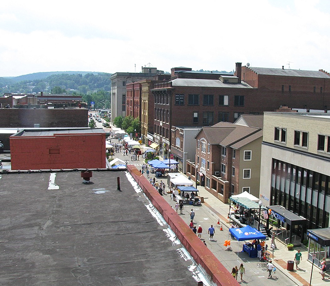 From above, Oil City's festival scene comes alive with colorful tents and community spirit, nestled between rolling Pennsylvania hills and historic buildings.