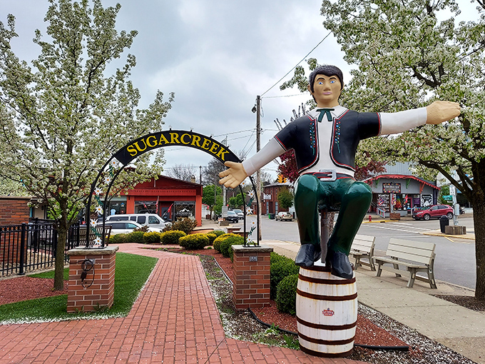 Sugarcreek's wooden ambassador stands at attention, perched atop his barrel like a jovial traffic cop directing visitors toward unexpected delight.
