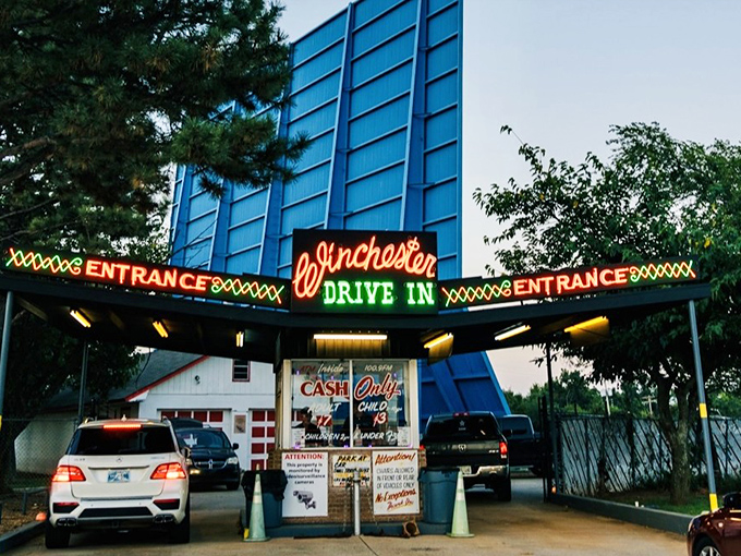That iconic neon sign beckons like a portal to simpler times—when entertainment didn't require passwords, just your car keys and sense of adventure.