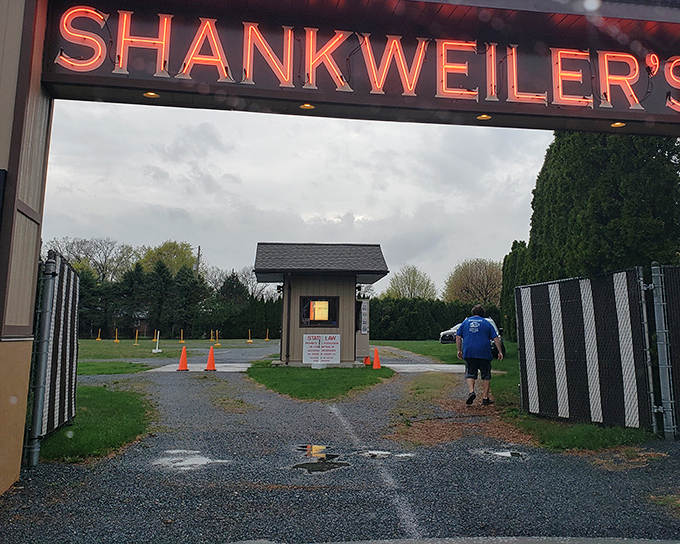 That iconic red neon sign beckons moviegoers through the entrance, promising an evening of nostalgic entertainment.